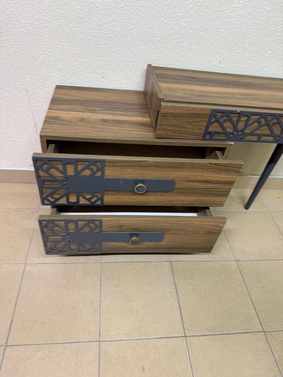 A modern dressing table with a wood-brown color and black geometric ...