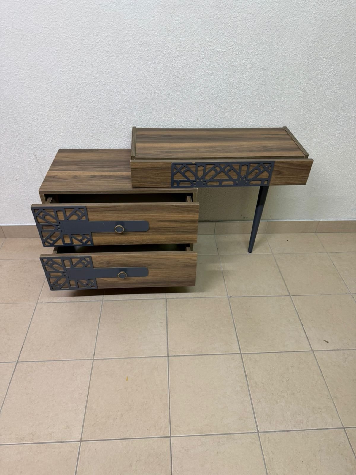 A modern dressing table with a wood-brown color and black geometric ...