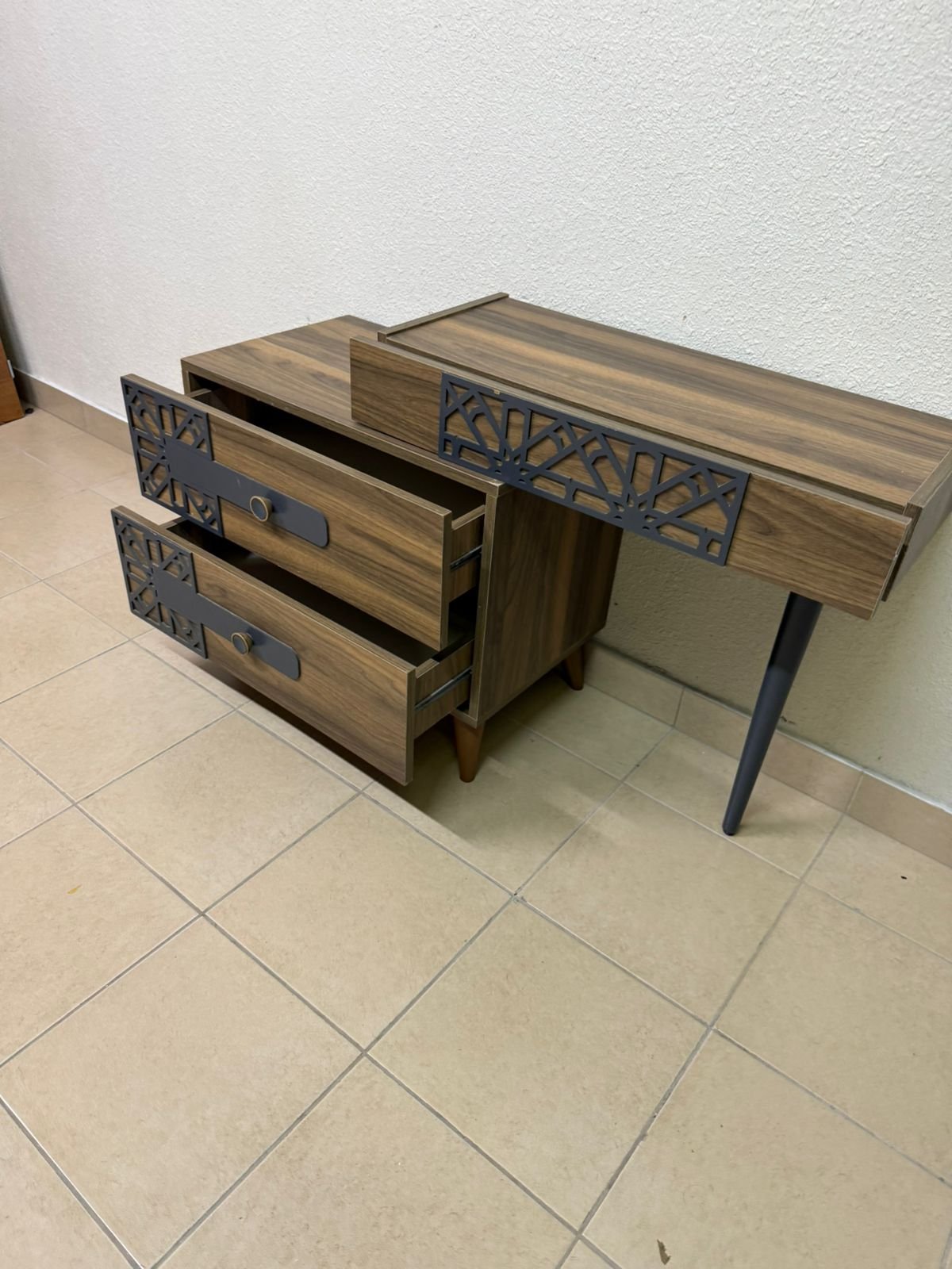 A modern dressing table with a wood-brown color and black geometric ...