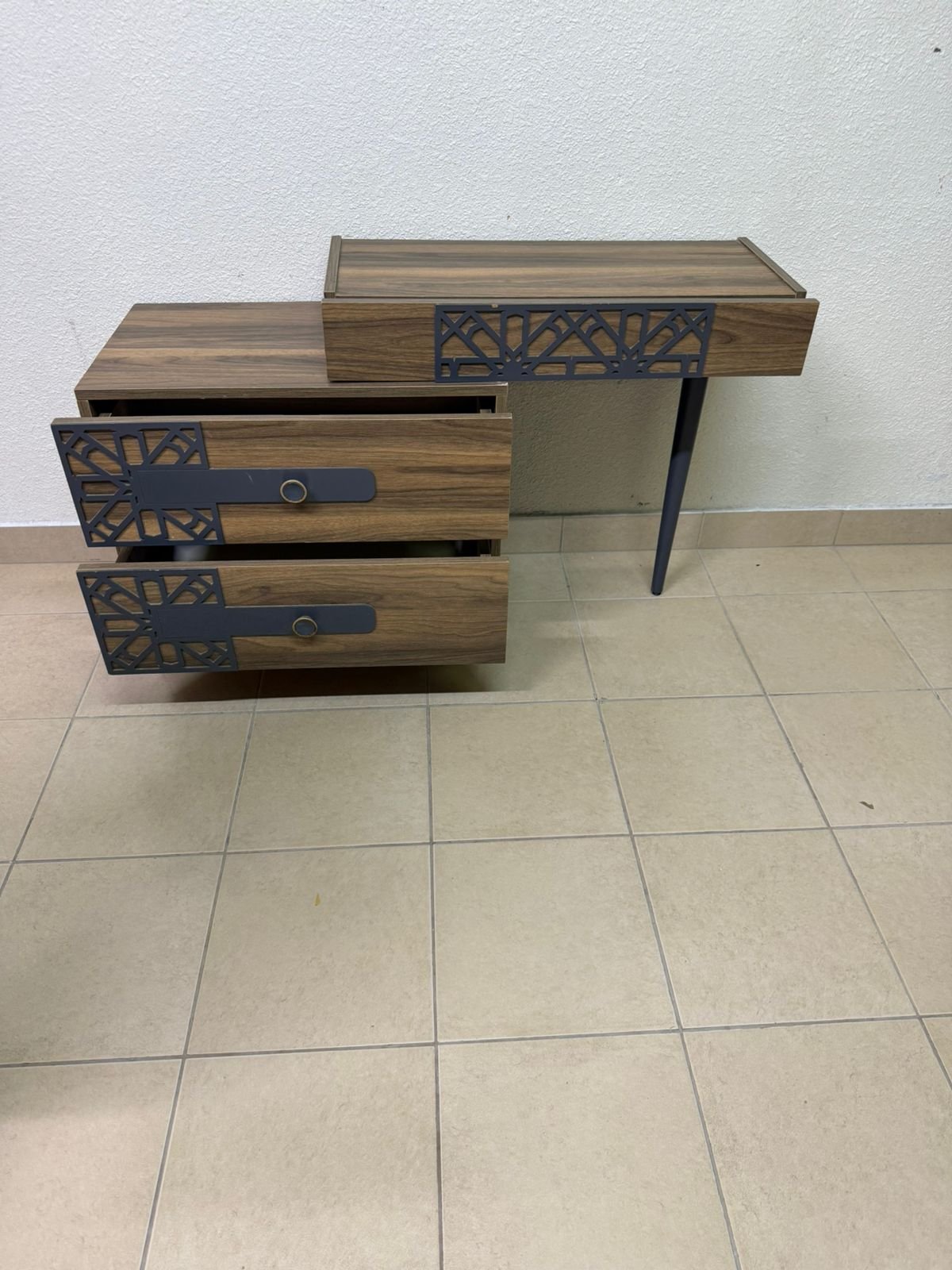 A modern dressing table with a wood-brown color and black geometric ...